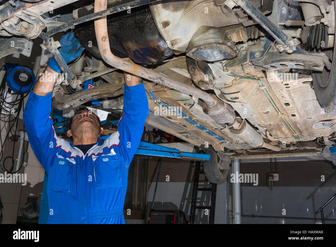 Car mechanic fixing an engine in his garage. copy space Stock Photo - Alamy