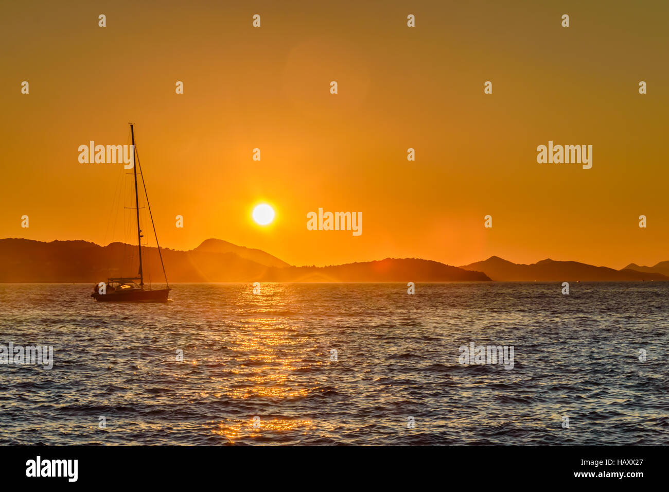 Boat sailing at sunset Stock Photo - Alamy
