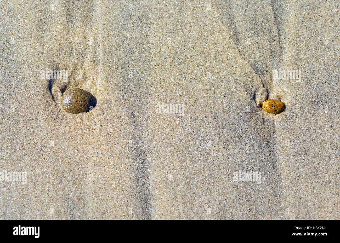 two rocks lying on the beach Stock Photo - Alamy
