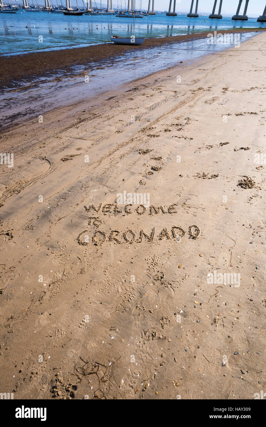 "Welcome To Coronado" written in the sand. Coronado Bridge in the ...