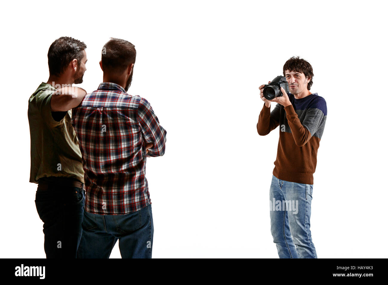 The three male friends with camera on white studio background Stock ...