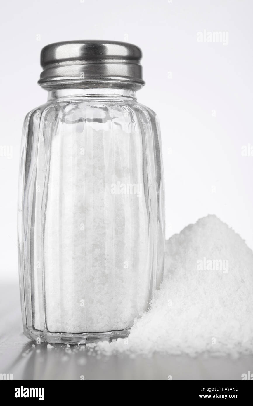 glass salt shaker on gray table and white background Stock Photo - Alamy