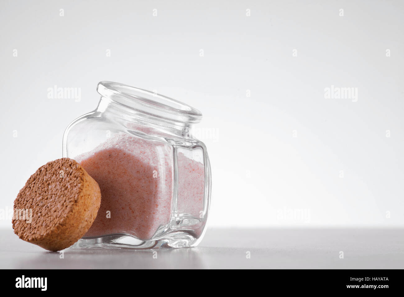 pink Himalayan salt in glass jar on white background with place for ...