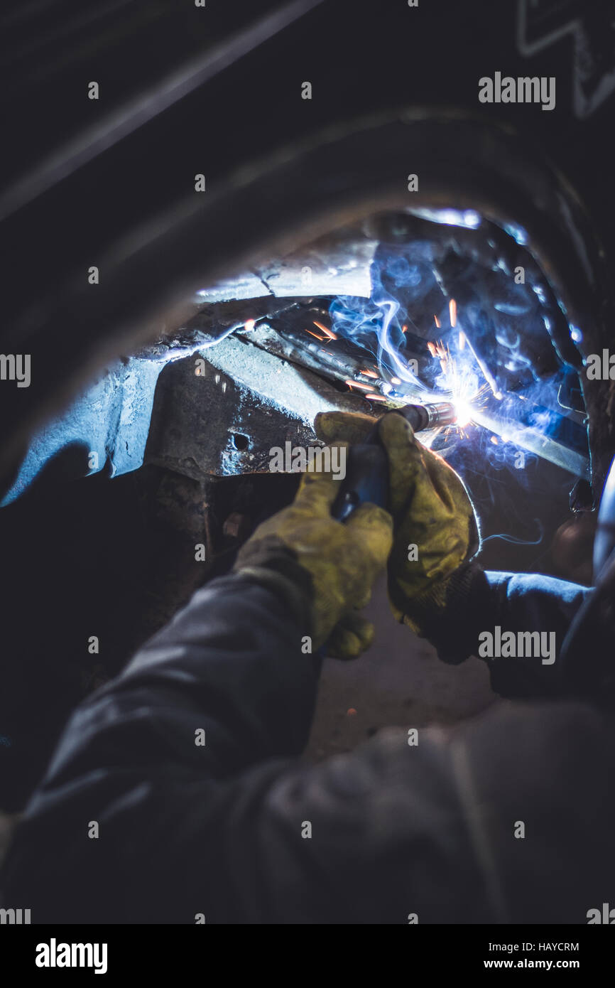 Mechanic welding on a car in an auto service repair shop Stock Photo ...
