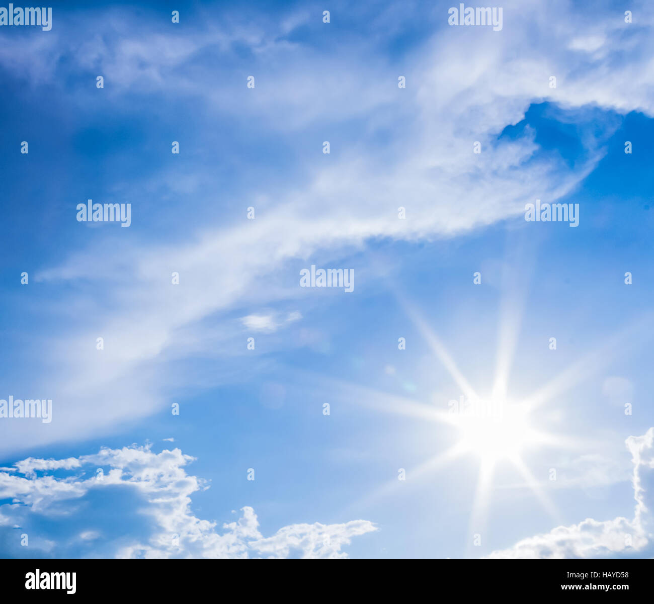 natural lens flare and radiating rays in a blue sky with clouds Stock ...