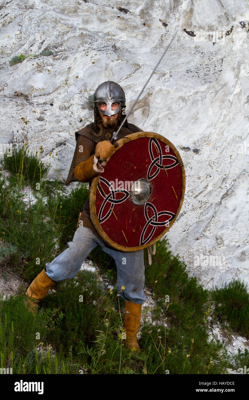 Knight on a rock with a sword against blue cloudy sky Stock Photo - Alamy