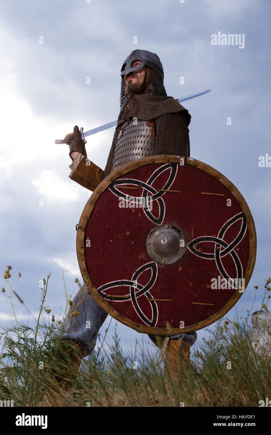 Knight on a rock with a sword against blue cloudy sky Stock Photo - Alamy