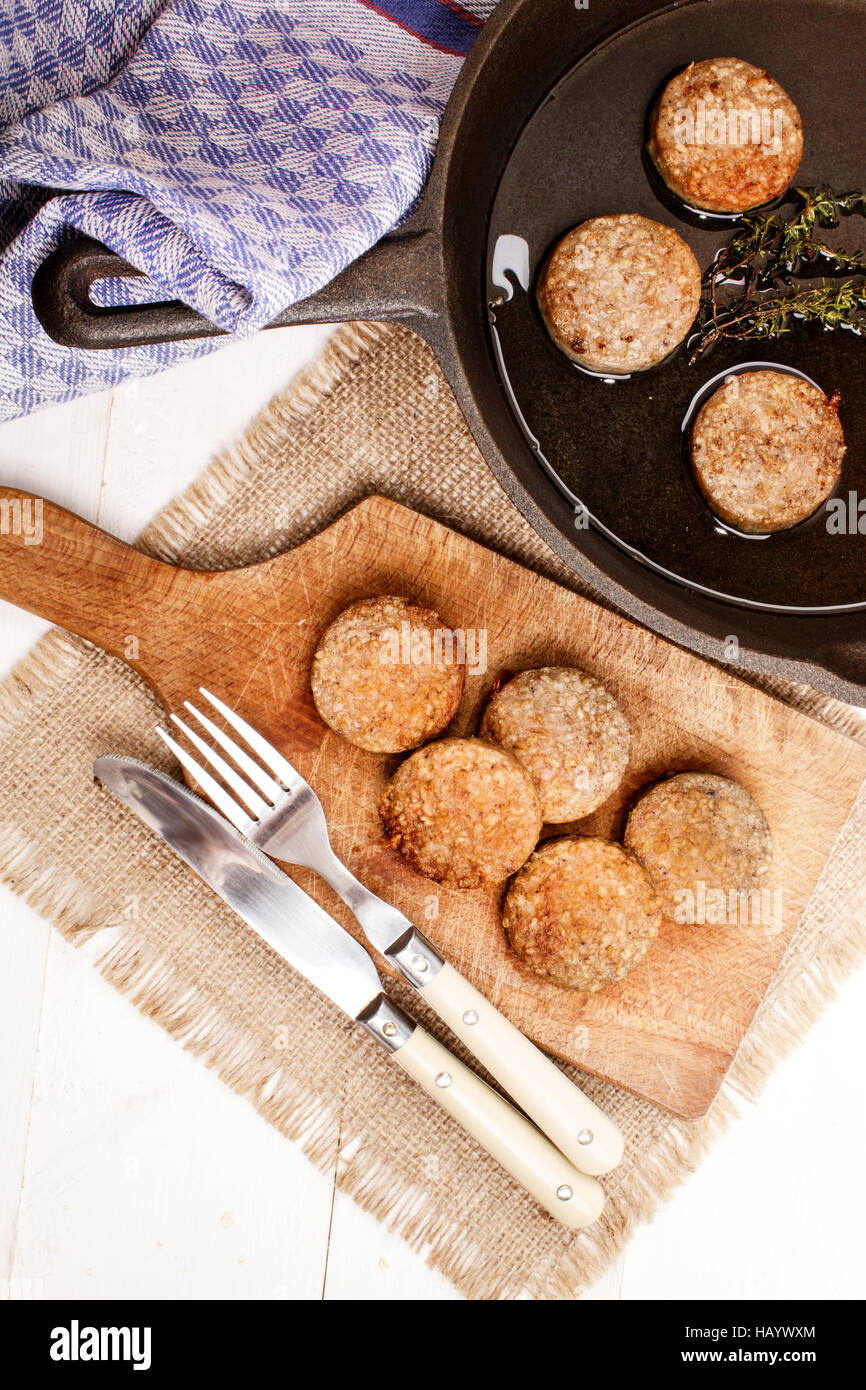grilled irish white pudding in a pan with thyme and on wooden board ...