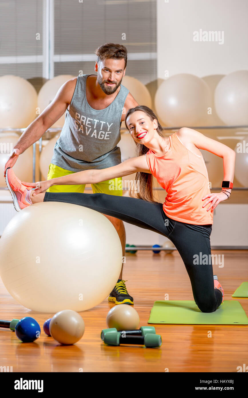 Woman exercising with fitball and personal tainer Stock Photo - Alamy