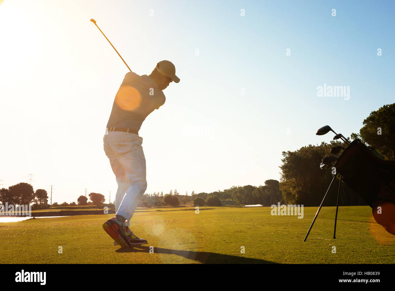 golf player hitting shot with club on course at beautiful morning with ...