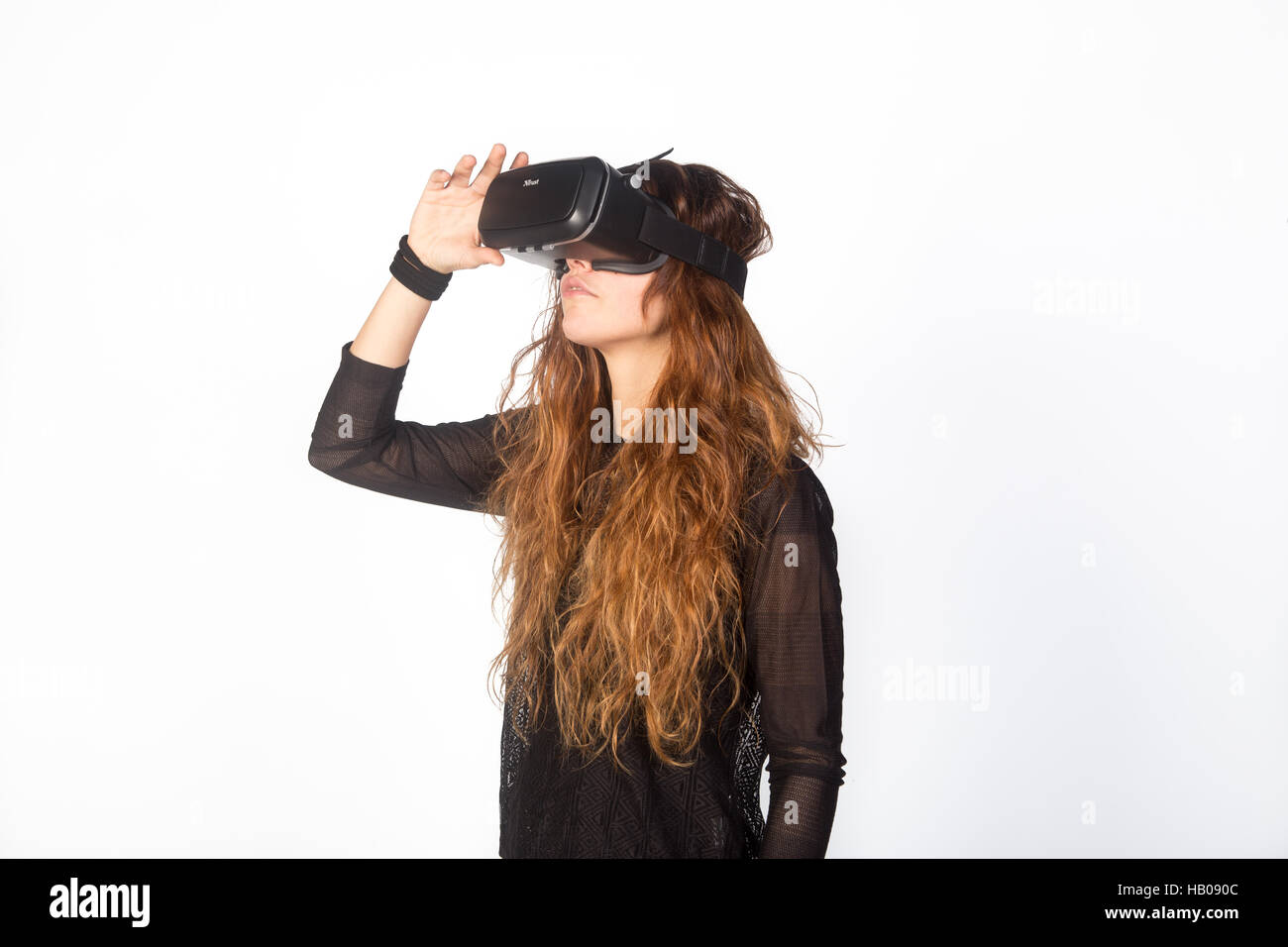Happy beautiful girl wearing virtual reality goggles VR 360 on isolated ...