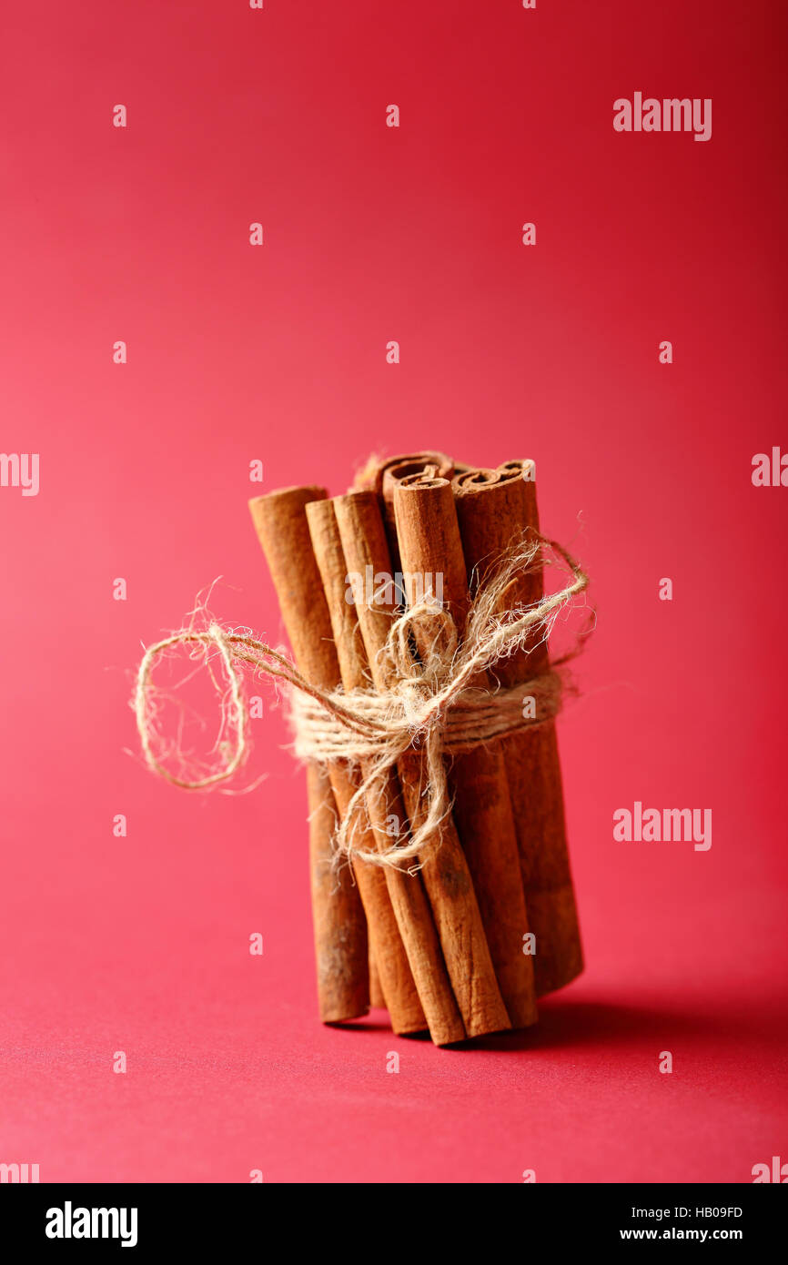 Cinnamon sticks on red background, food Stock Photo - Alamy