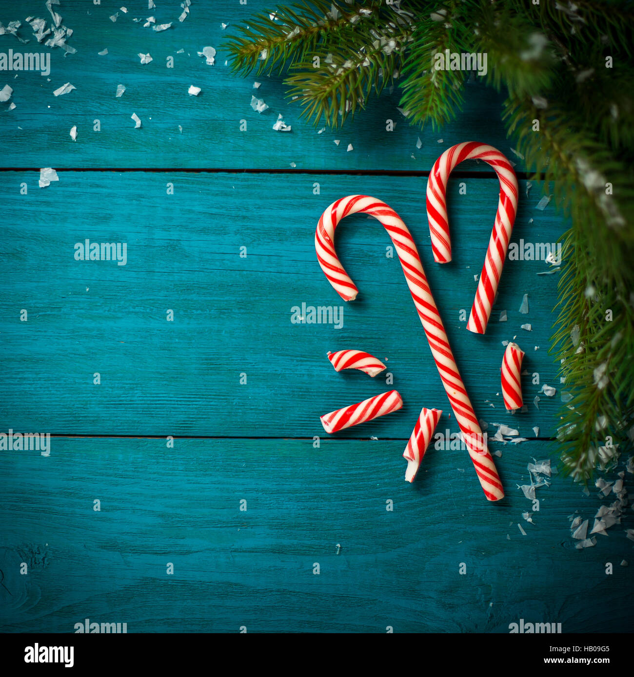 Christmas tree branch with candy cane on wooden table. Top view with ...