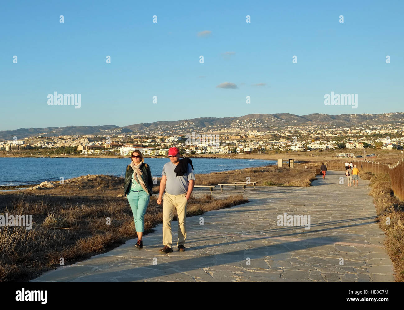People walk along the Paphos coastal path in Kato Paphos, Paphos ...
