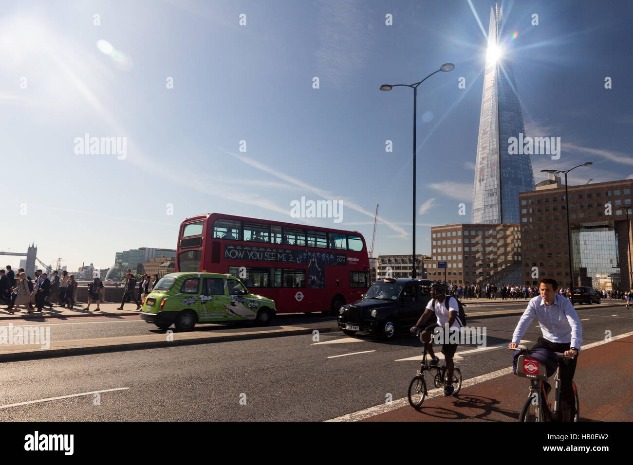 Cycling to work across London Bridge during the morning traffic, with ...