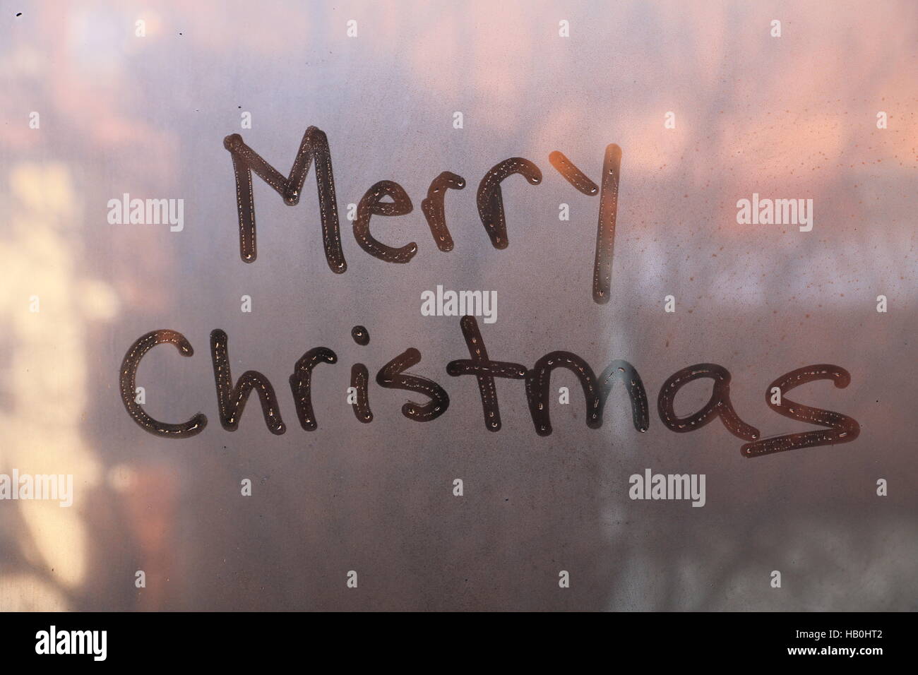 Merry Christmas text written on the glass Stock Photo - Alamy