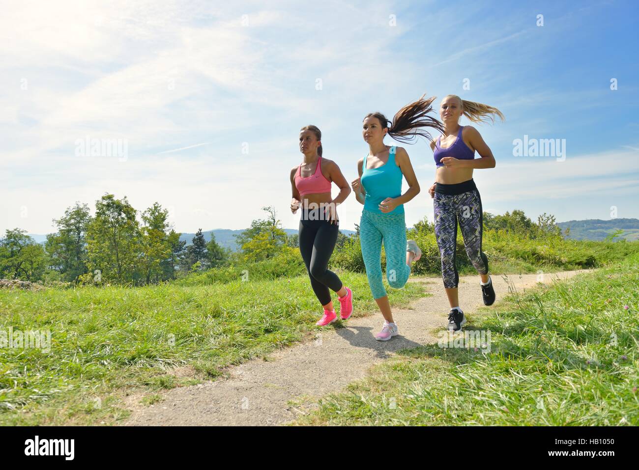 Three Female Joggers running together outdoors Stock Photo - Alamy