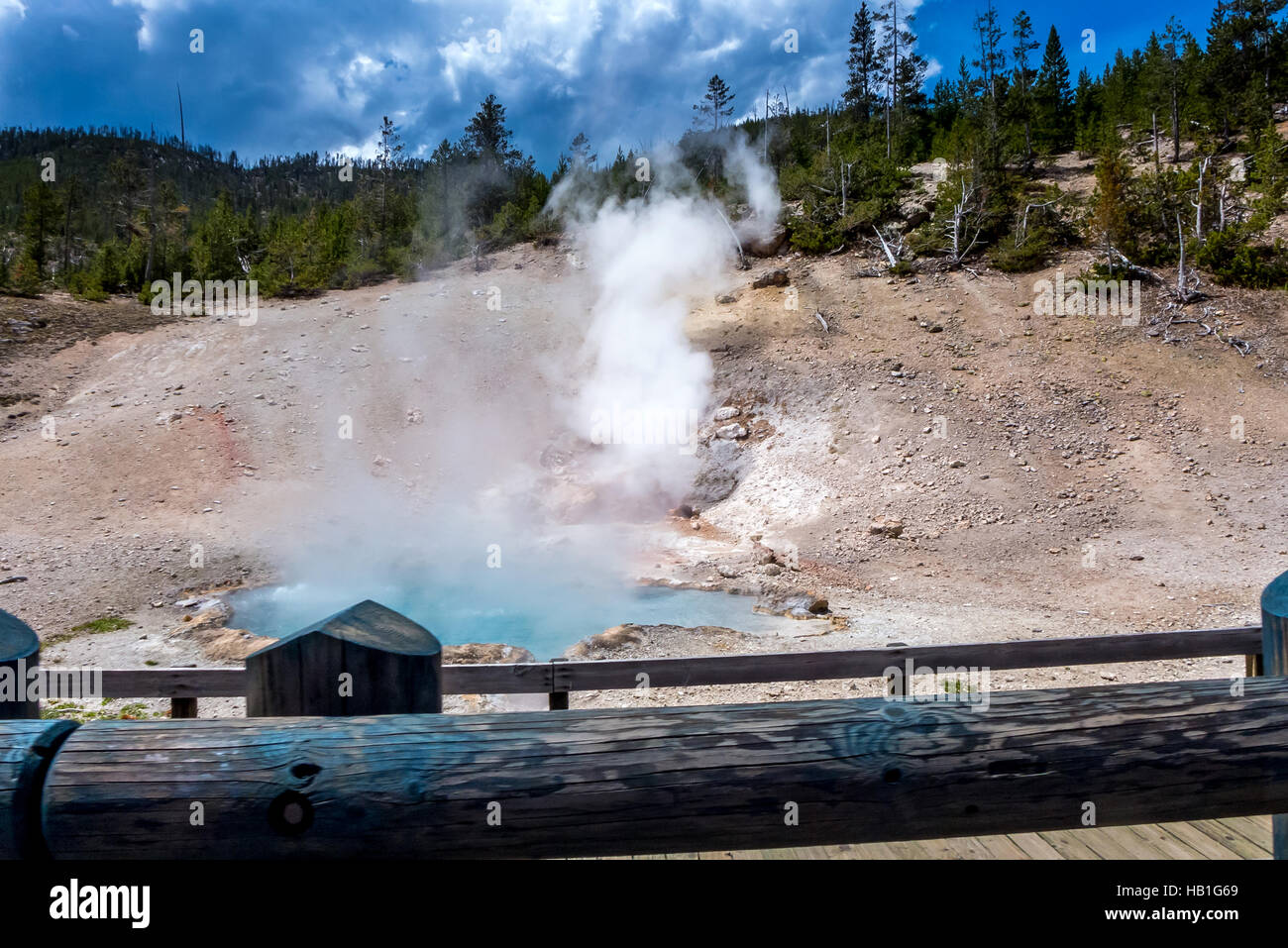 A natural geyser by the side of the road in Yellowstone National Park ...