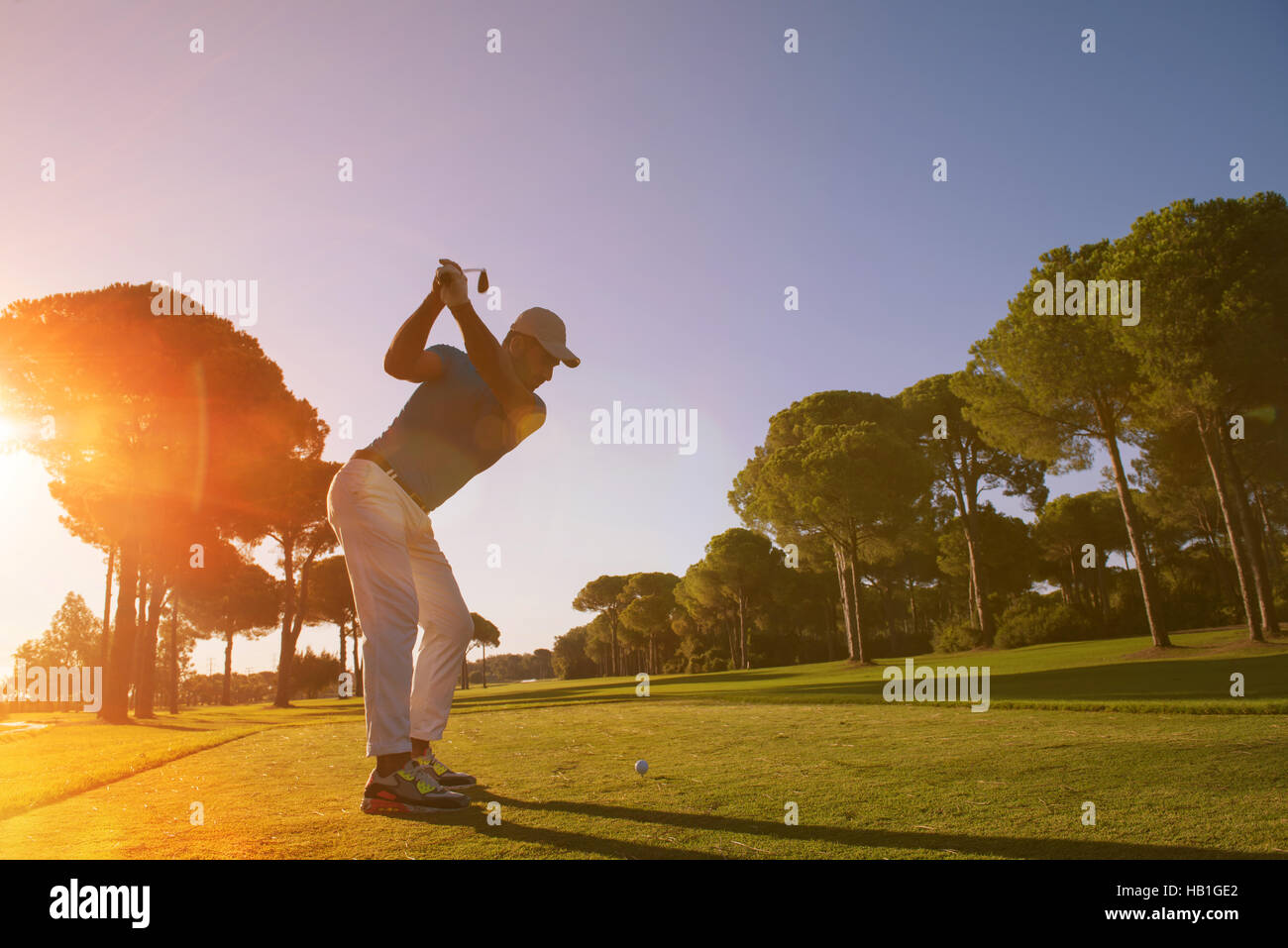 golf player hitting shot with club on course at beautiful morning with ...