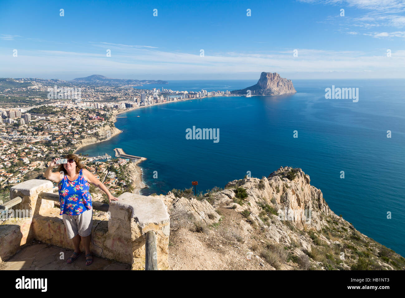 Woman taking selfie high up with view of Calp, Calpe port, and the ...