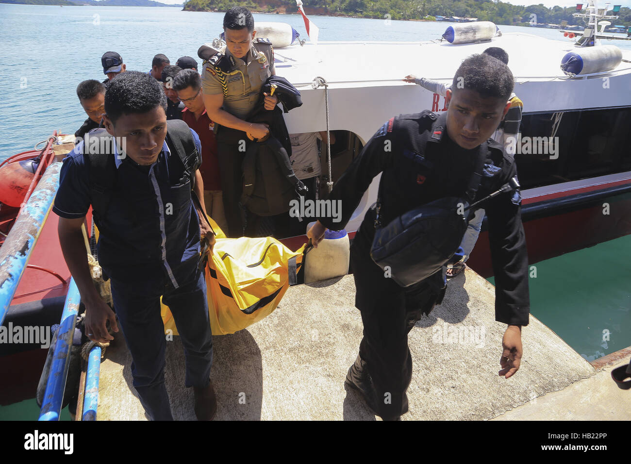 Batam, Indonesia. 4th Dec, 2016. Police officers carry a body bag ...