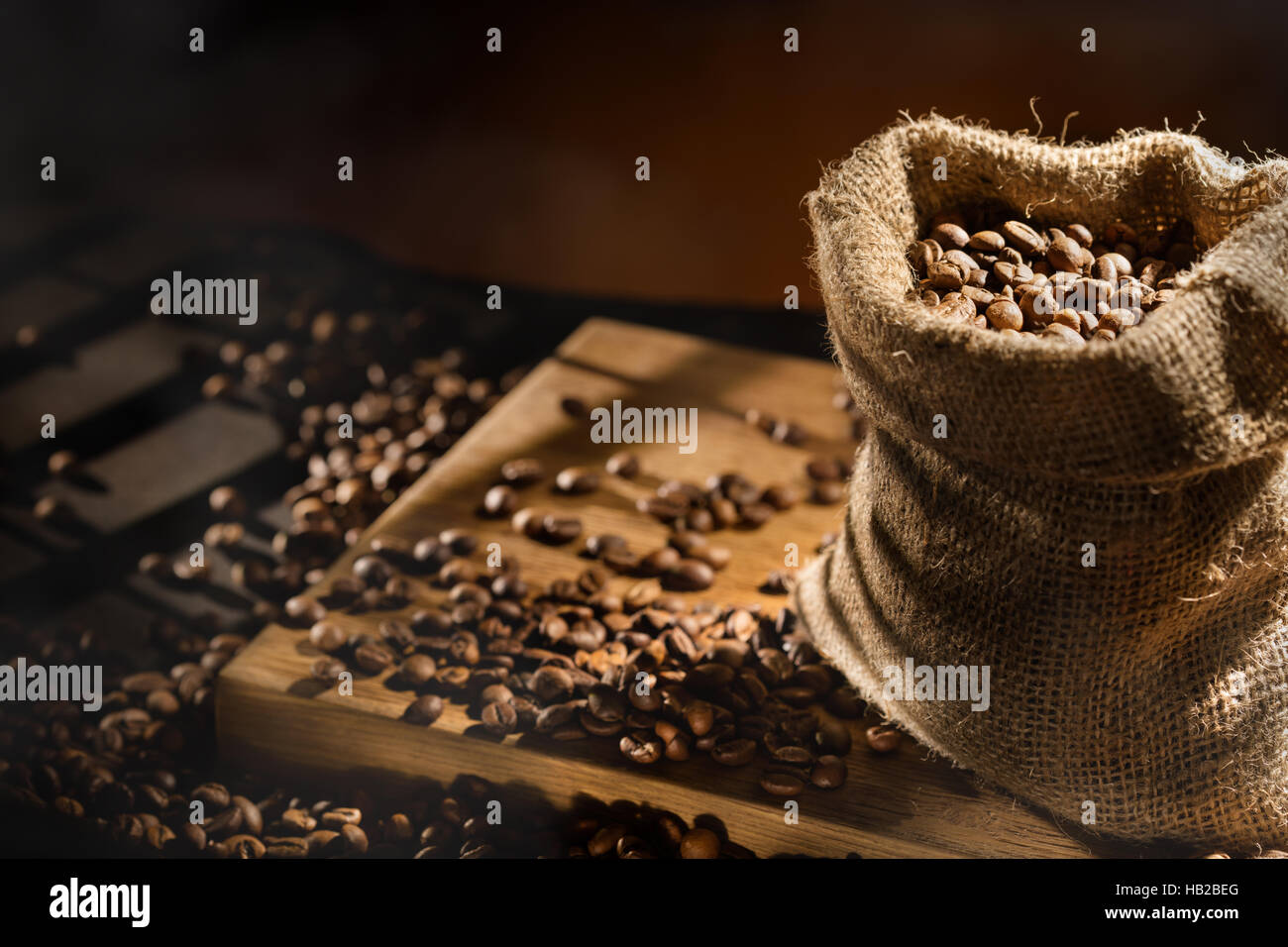 spilled coffee beans in bag on wood Stock Photo - Alamy