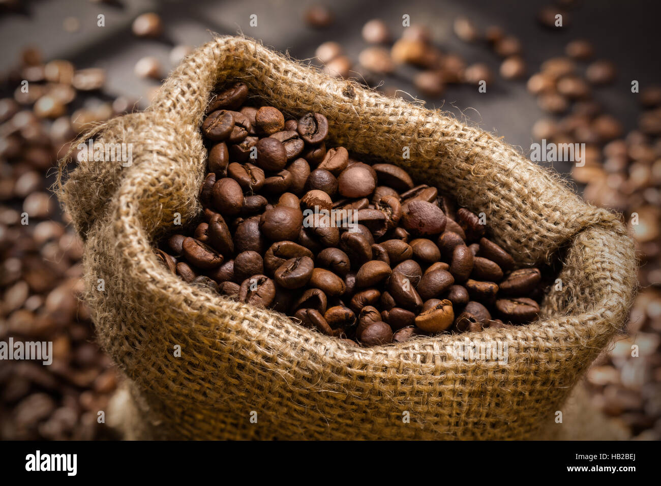 spilled coffee beans in bag on wood Stock Photo - Alamy
