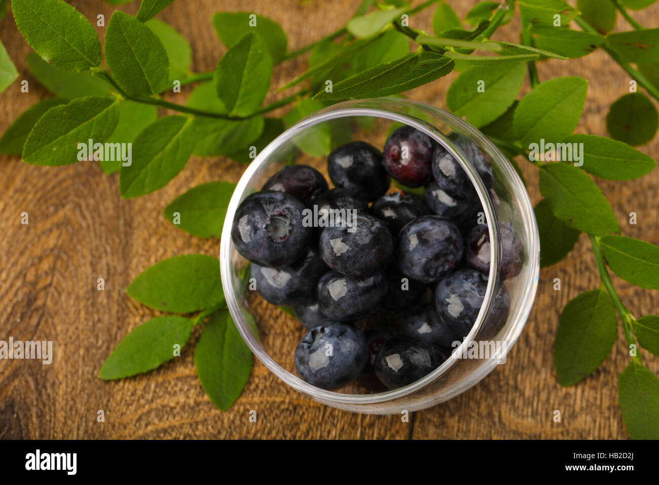 Ripe Blueberry heap with leaves on wood background Stock Photo - Alamy