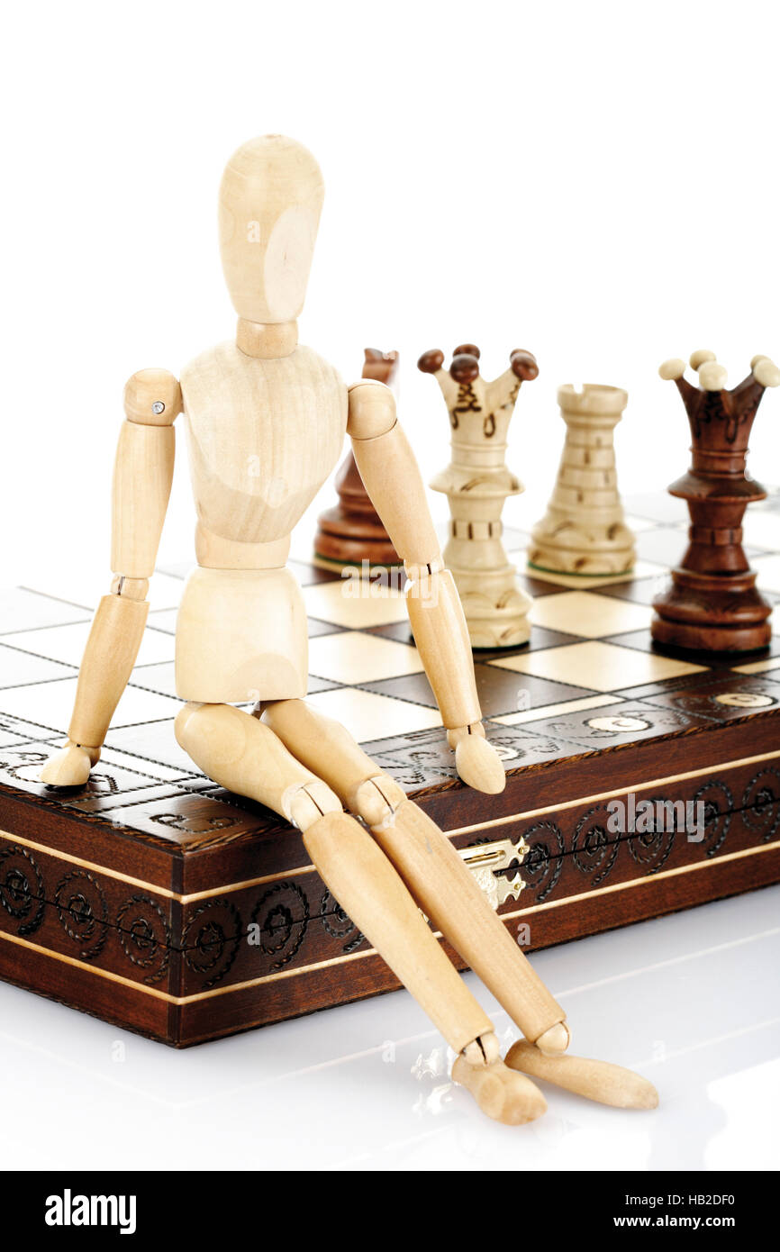 Wooden jointed figure with a game of chess Stock Photo - Alamy