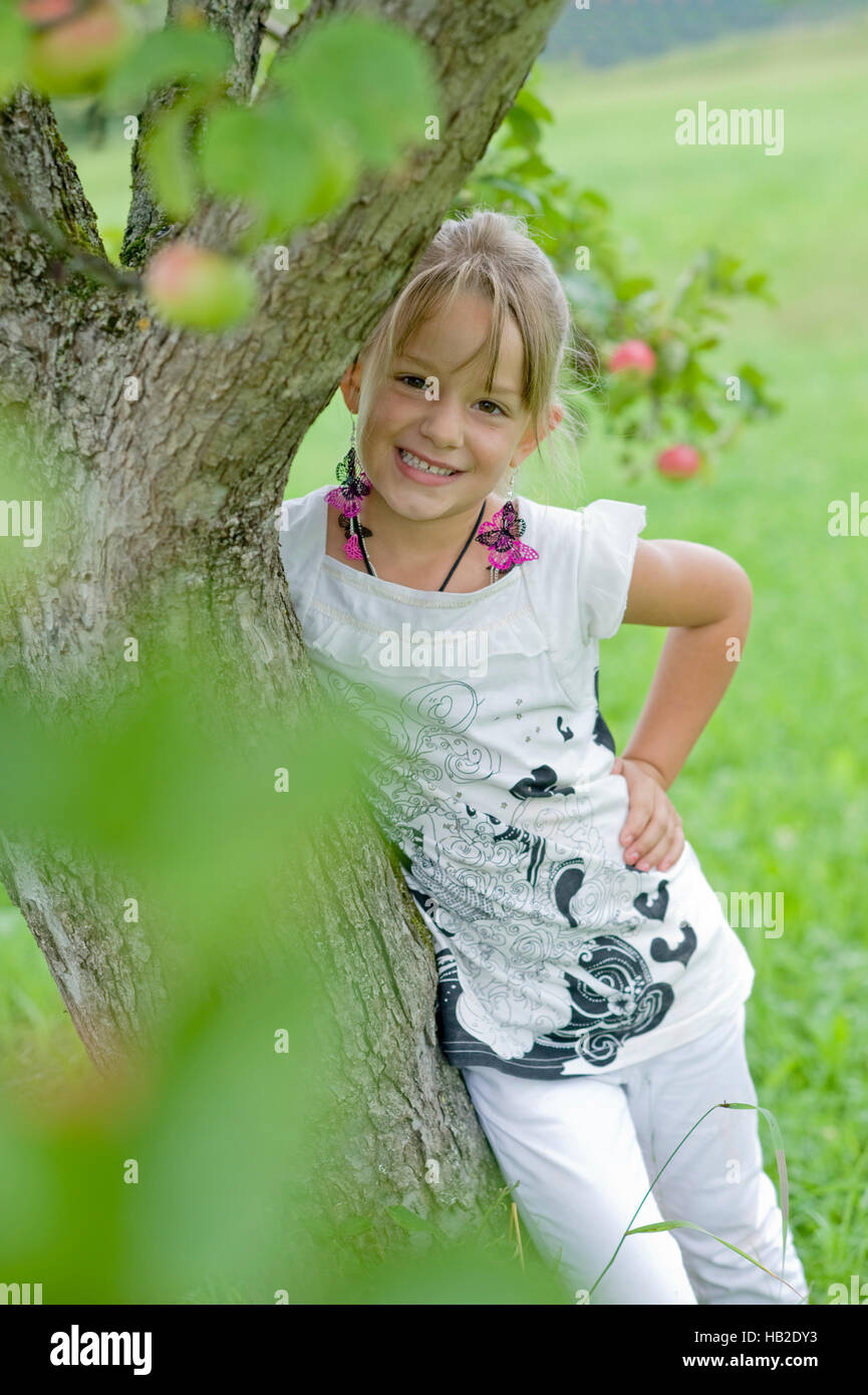 Blond girl, 6, under an apple tree, portrait Stock Photo - Alamy