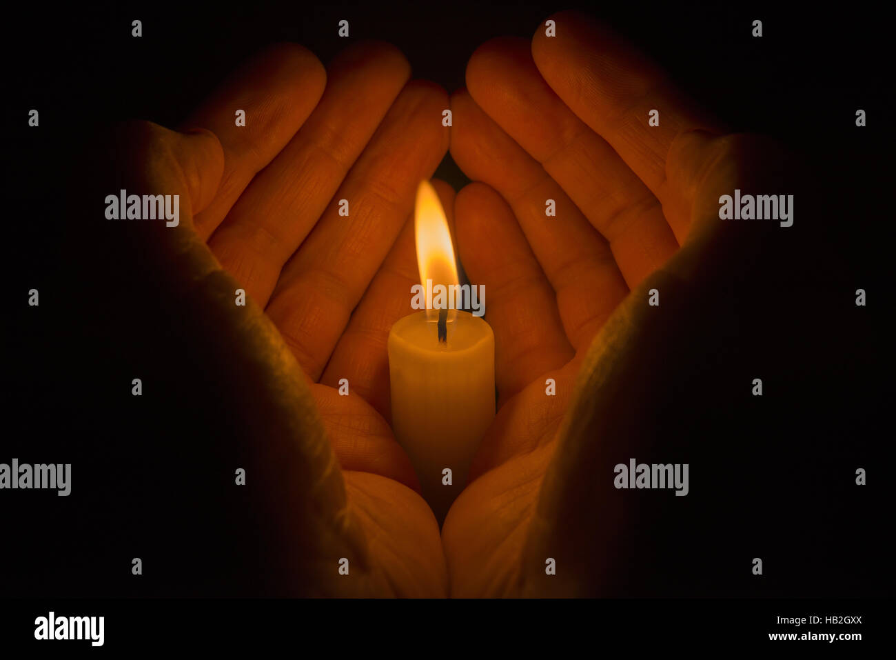 Protective hands around a burning candle Stock Photo - Alamy