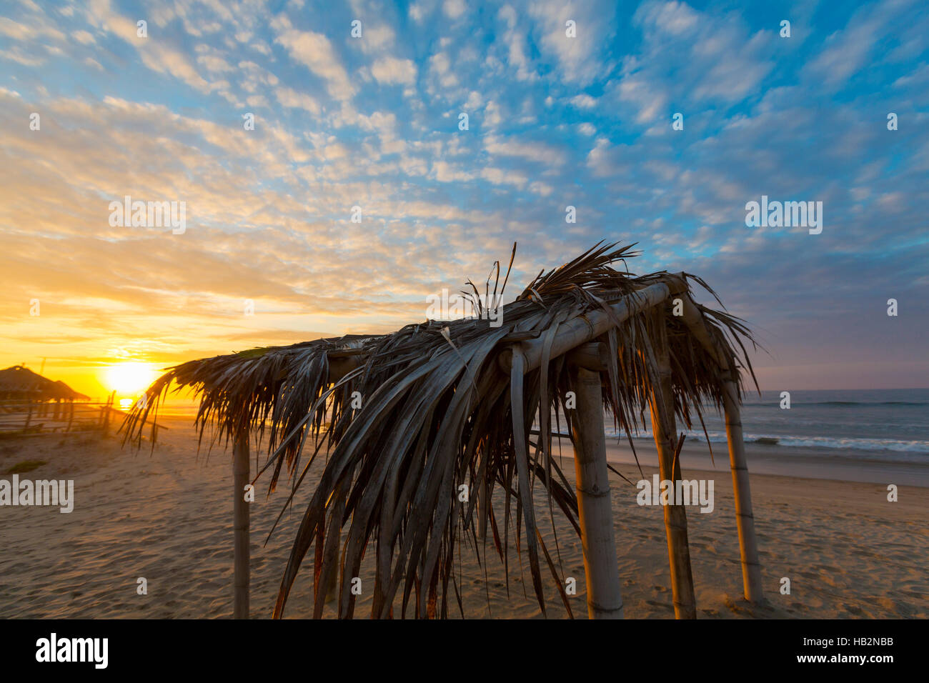 Sunset on Punta Sal beach with wooden shelters, Peru Stock Photo - Alamy