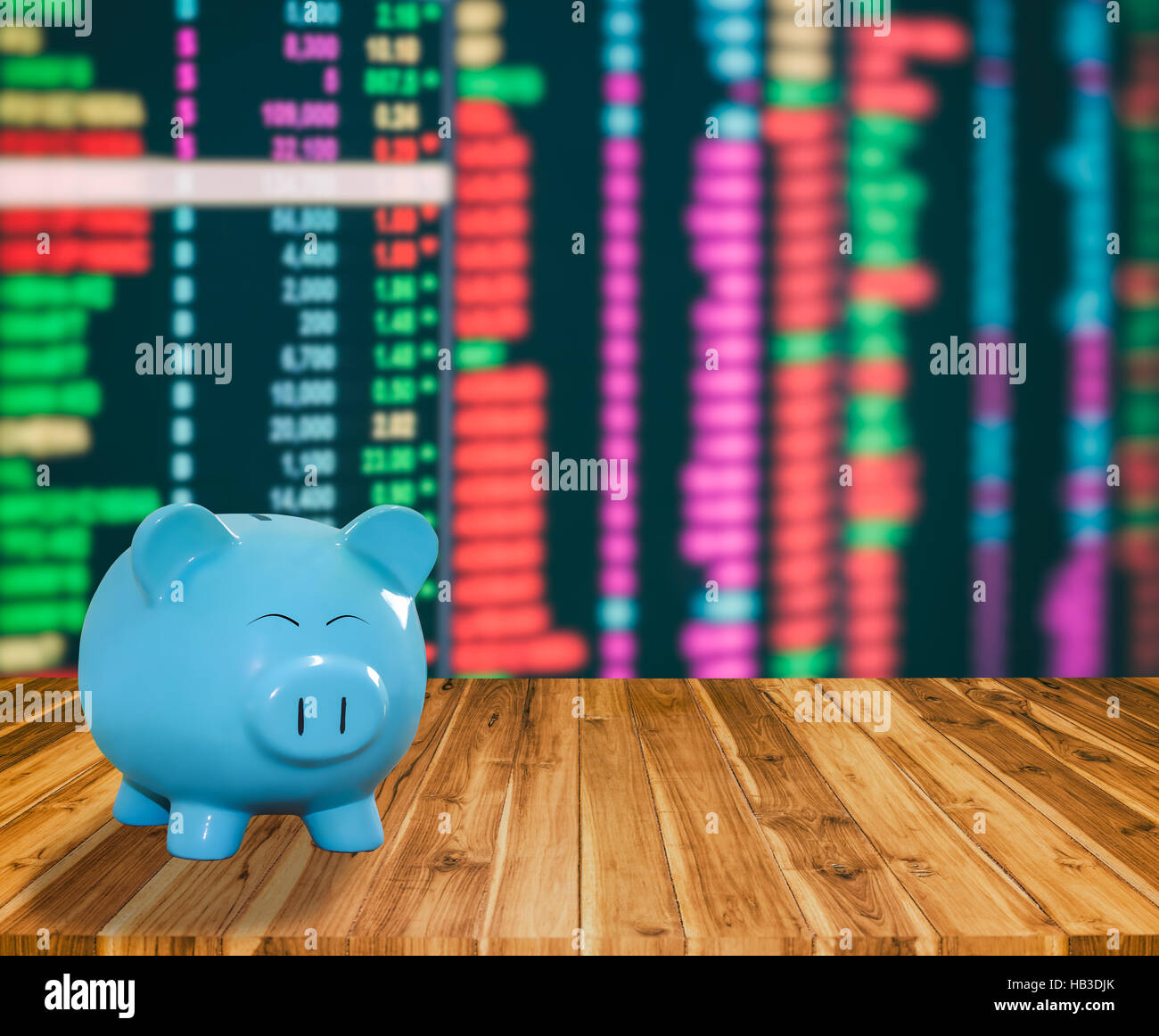 blue pig bank on wood background with blur stock market background ...