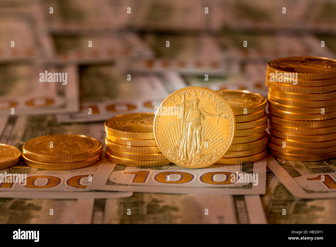 Gold coins stacked on new design 100 dollar bills Stock Photo - Alamy