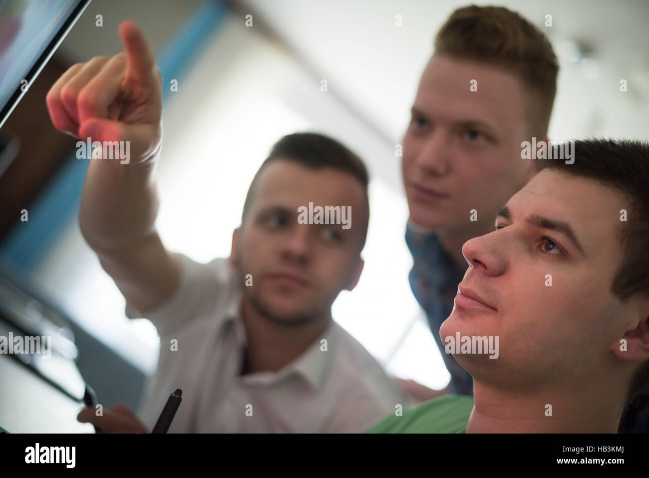 a group of young graphic designers working on a digital tablet and a ...