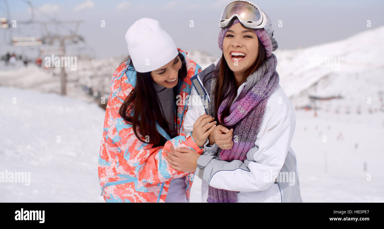 Two happy playful young ladies at a ski resort Stock Photo - Alamy