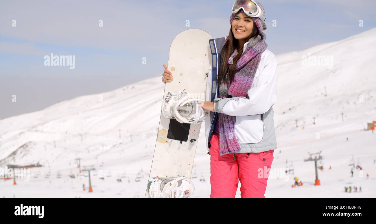 Smiling gorgeous woman posing with her snowboard Stock Photo - Alamy
