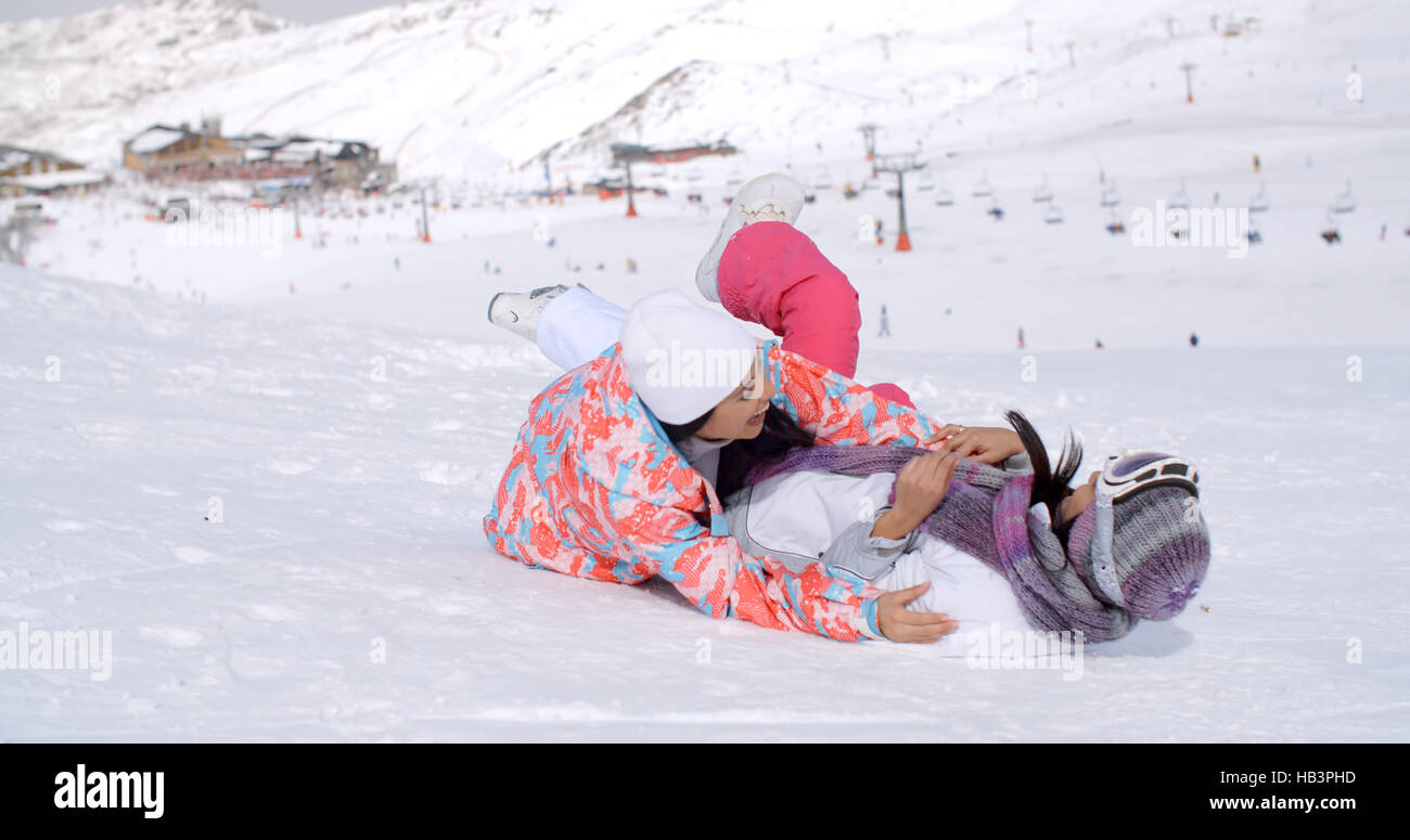Two young woman enjoying a frolic in the snow Stock Photo - Alamy