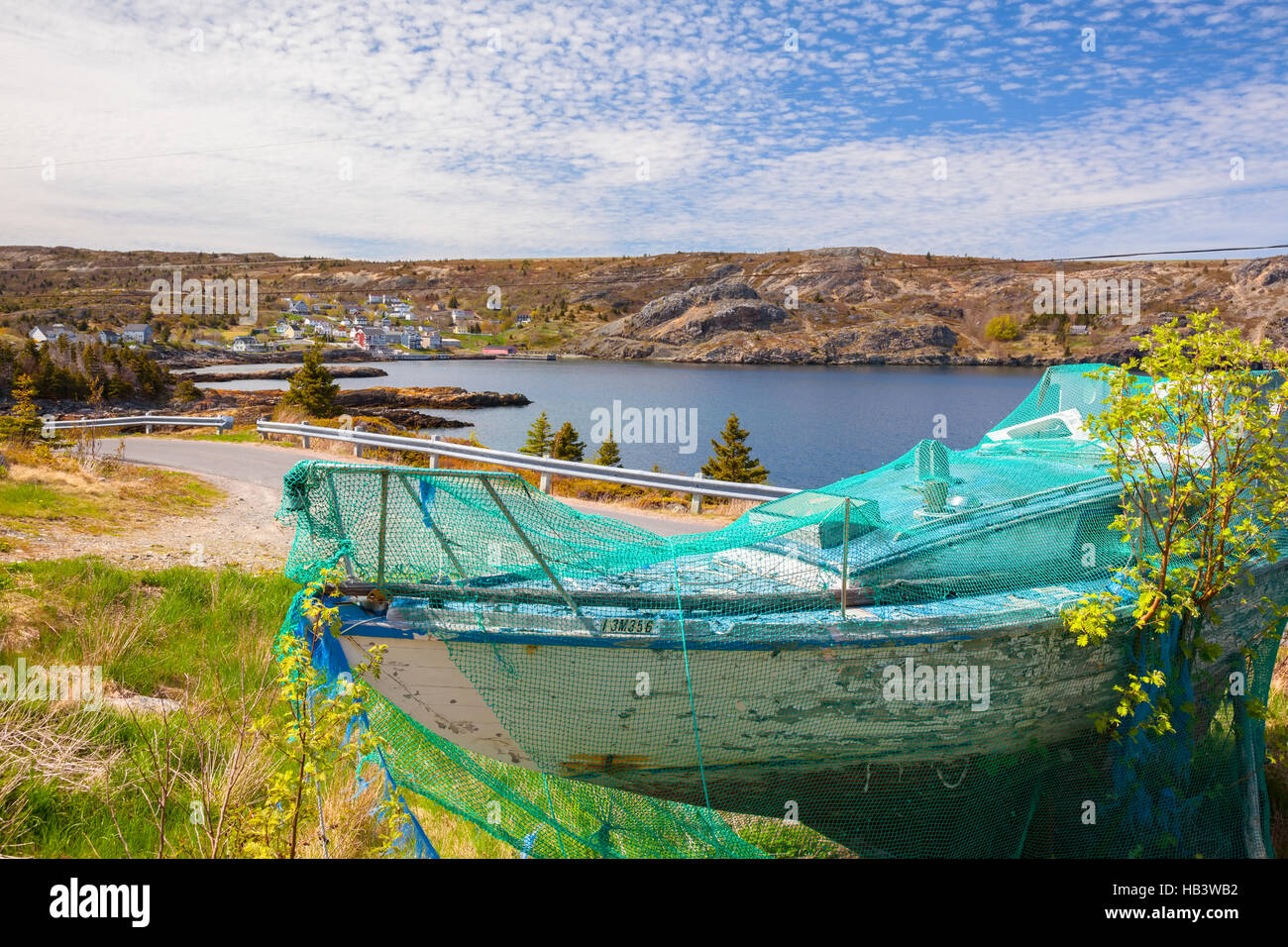 A old dilapidated fishing vessel covered by a fishing net with the town ...