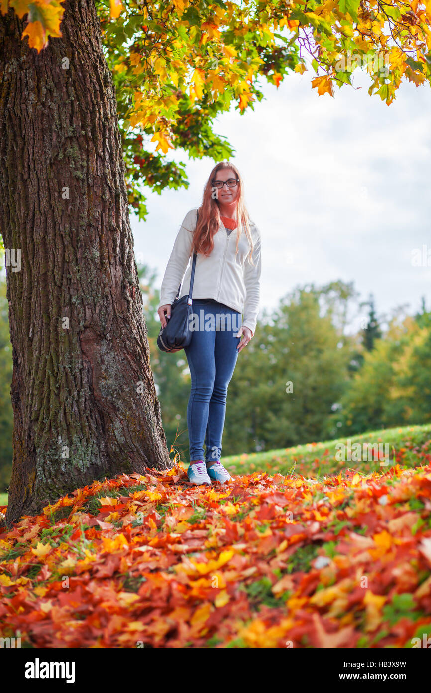 Beautiful woman in autumn park under fall foliage at warm day. Autumn ...