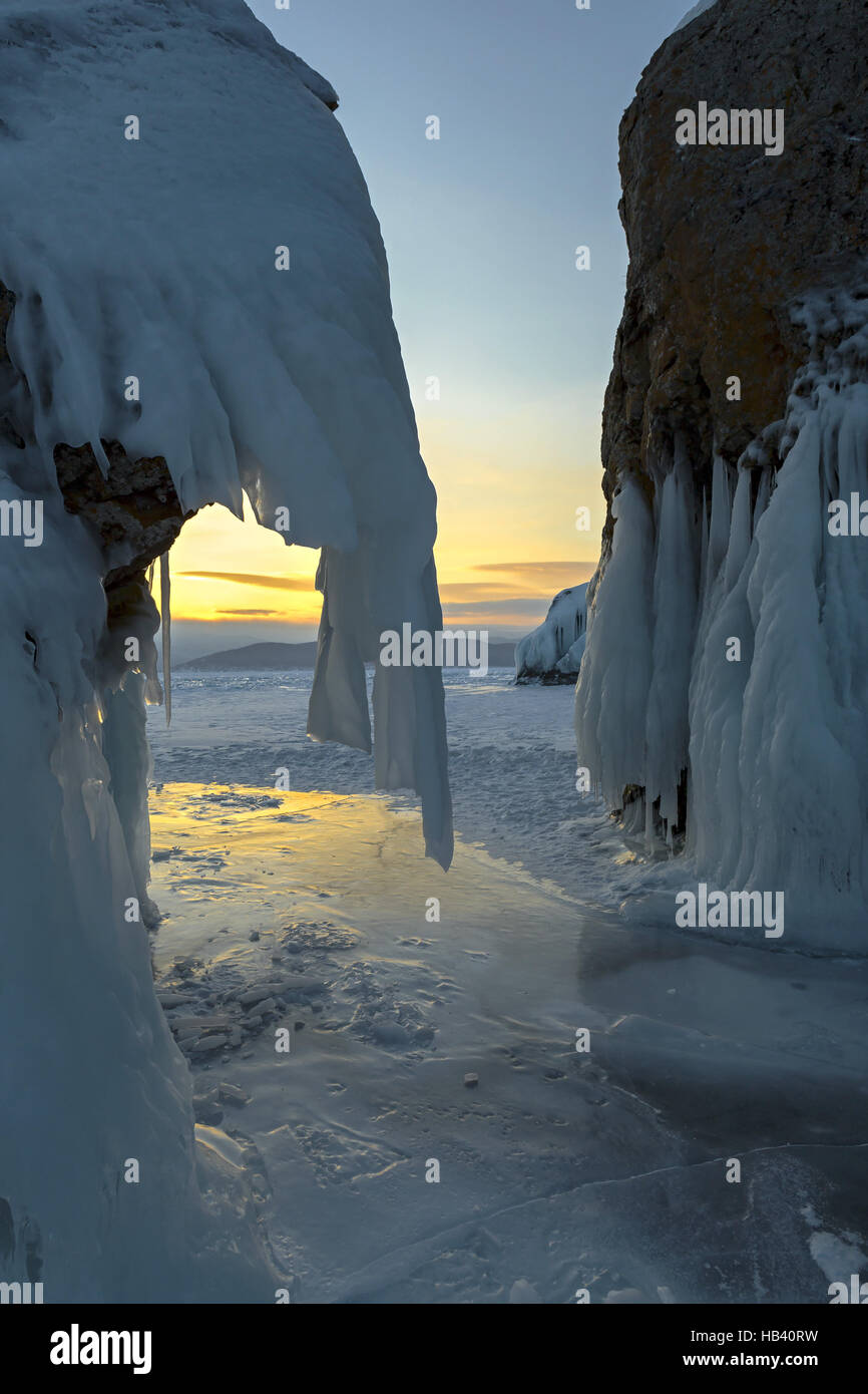 Huge icicles on rocks at sunrise Stock Photo - Alamy