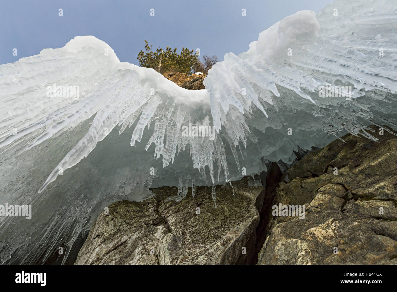 Huge icicles on rocks Stock Photo - Alamy