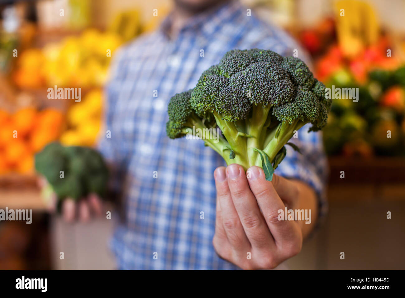 Man holding broccoli at arm's length Stock Photo - Alamy