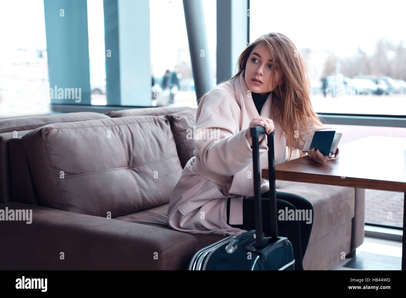 Woman sitting on the couch in a hall Stock Photo - Alamy