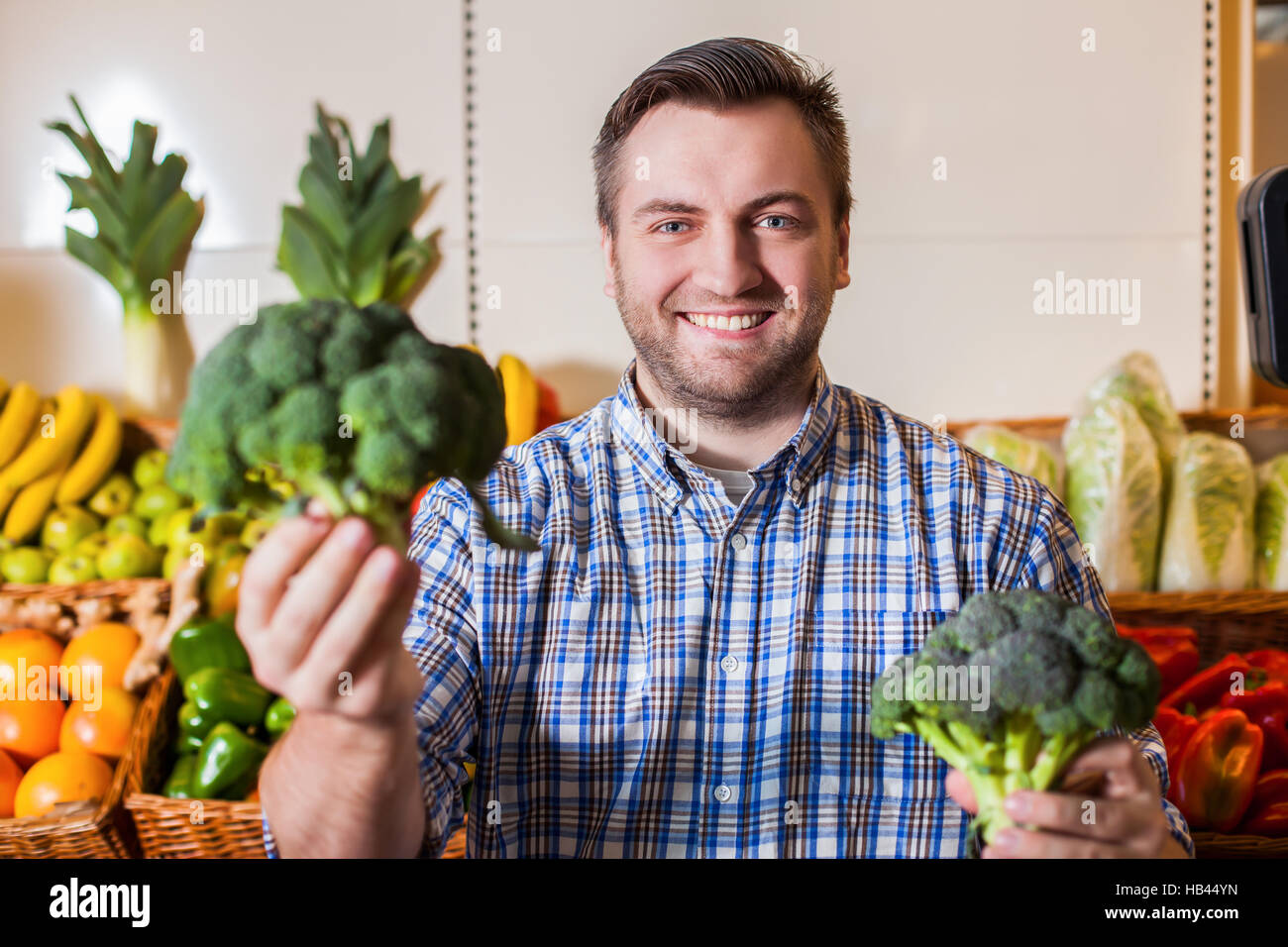 Man holding broccoli at arm's length Stock Photo - Alamy