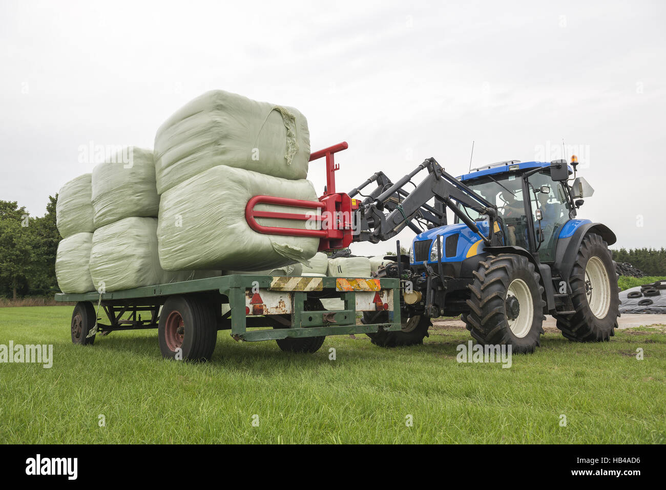 Agriculture loading of plastic hay bales Stock Photo - Alamy