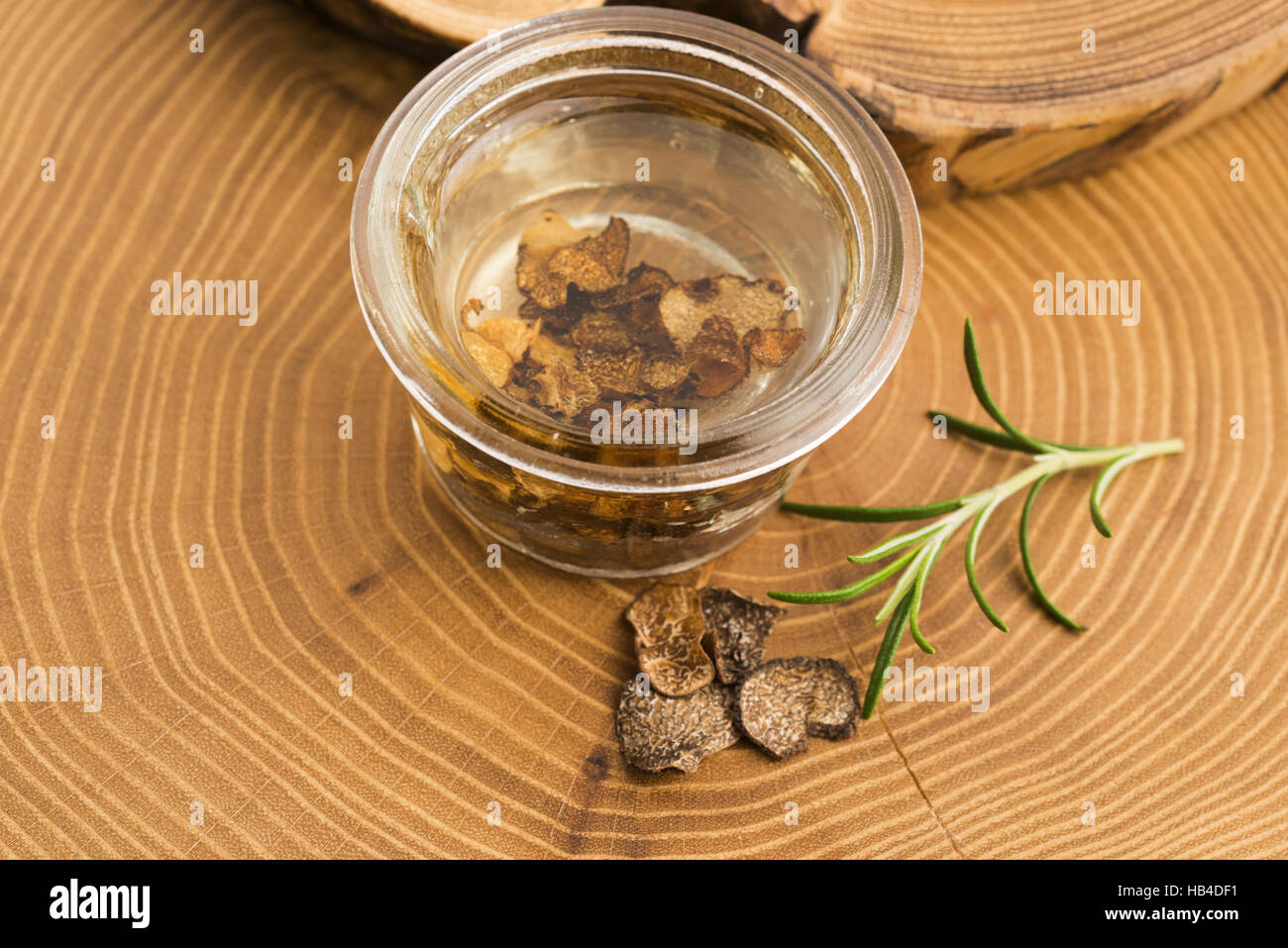 Sliced black truffle in olive oil in small jar and fresh rosemary Stock ...