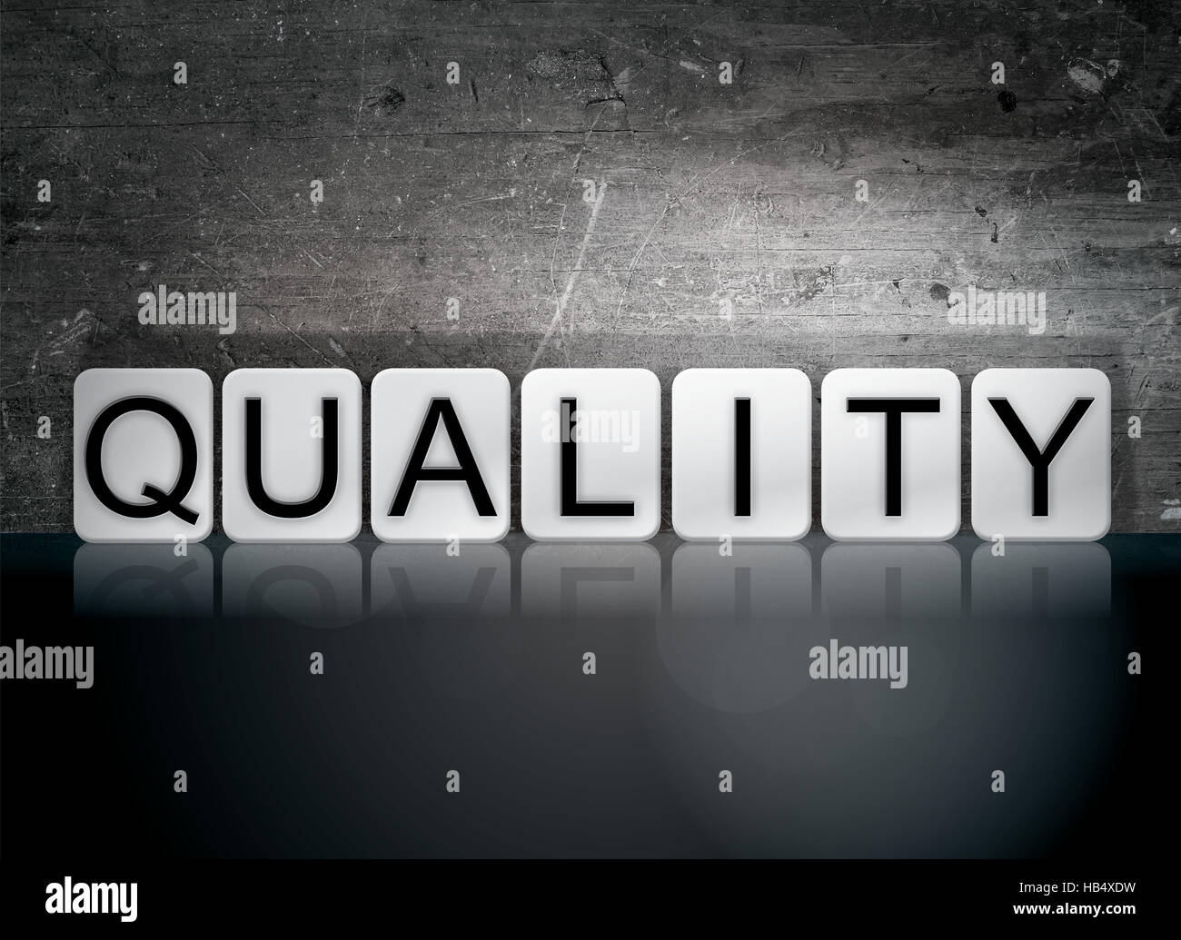 The word "Quality" written in white tiles against a dark vintage grunge ...