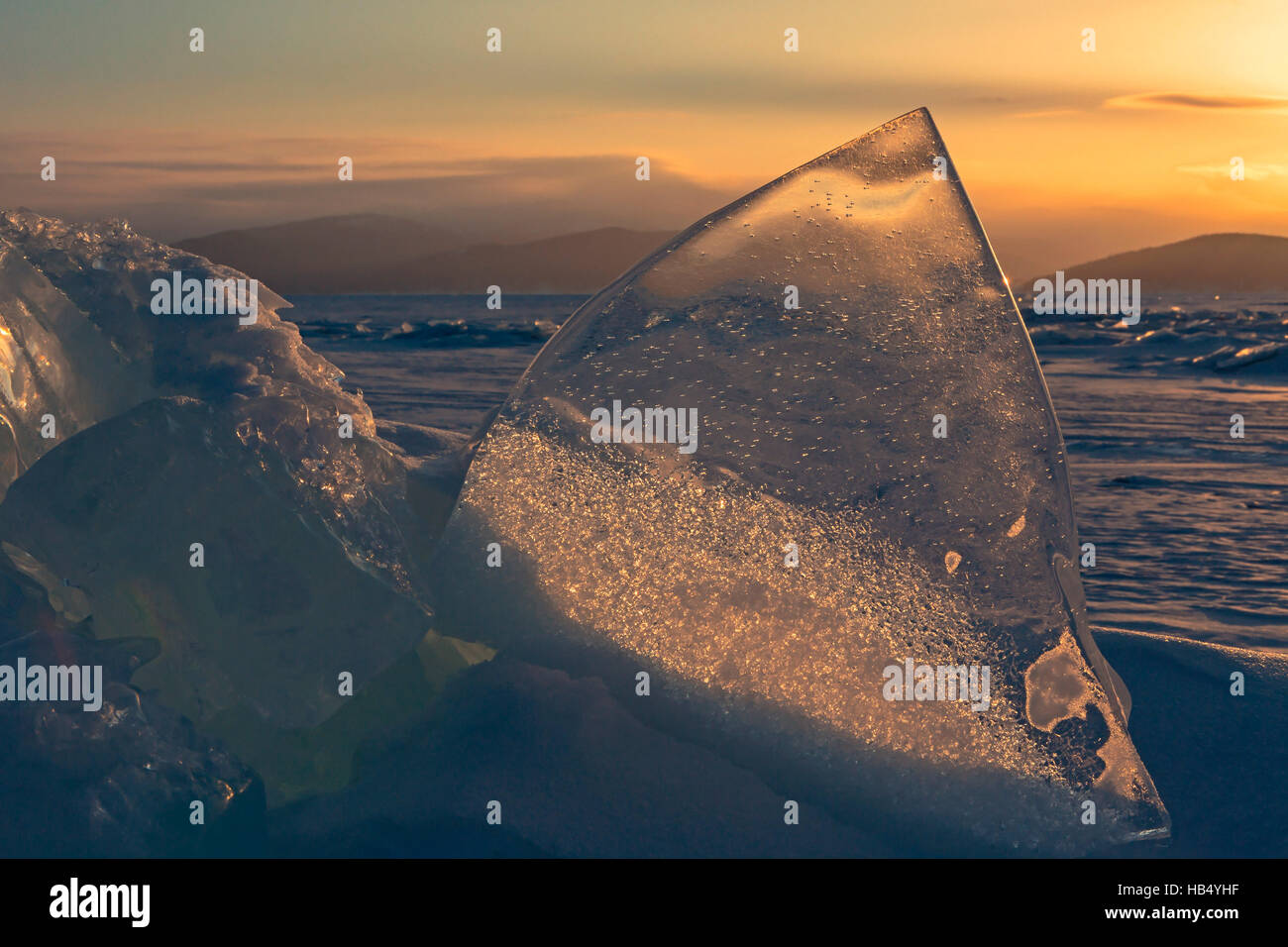 Transparent piece of ice on sunset sky background Stock Photo - Alamy