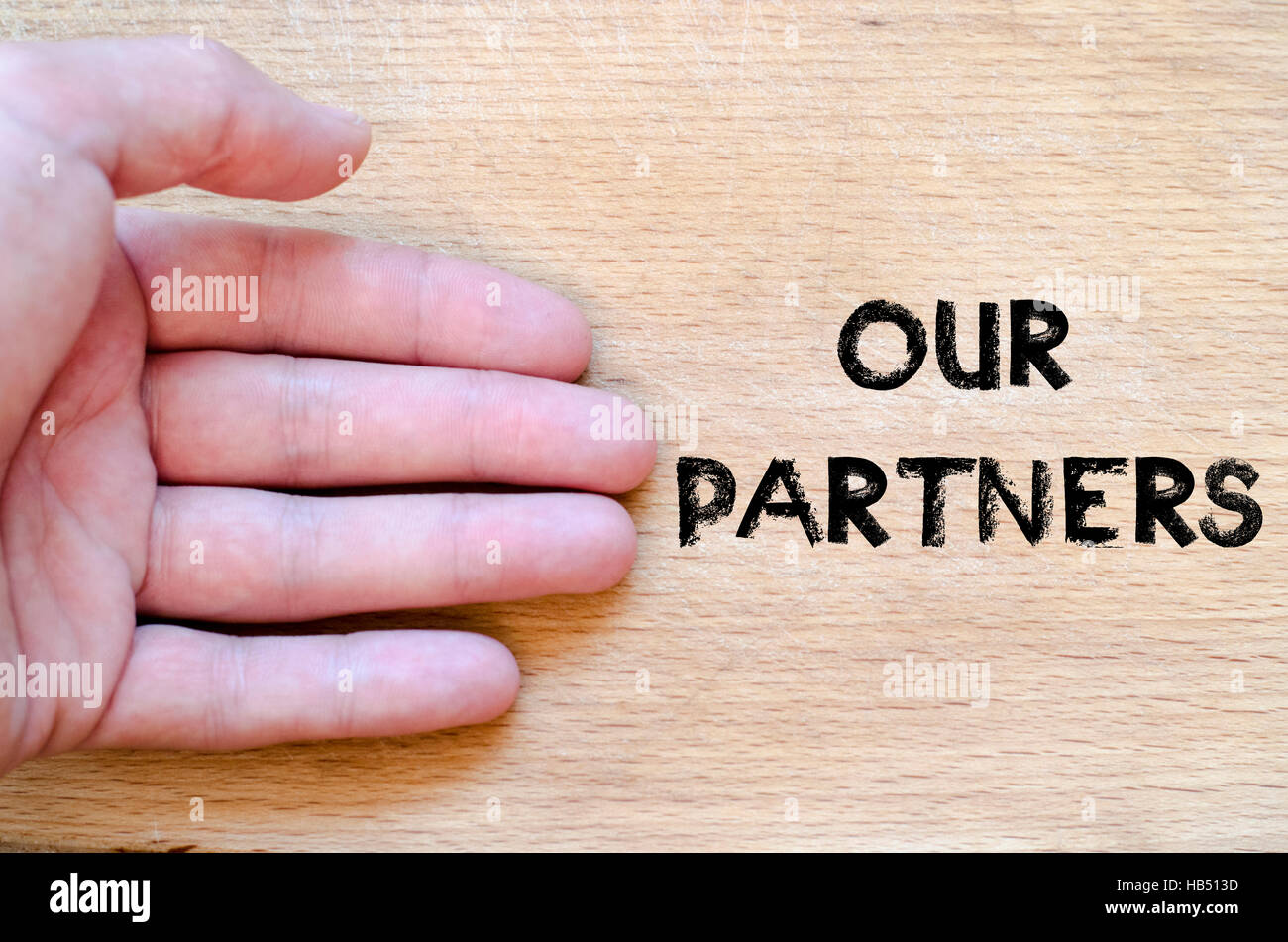 Human hand over wooden background and our partners text concept Stock ...